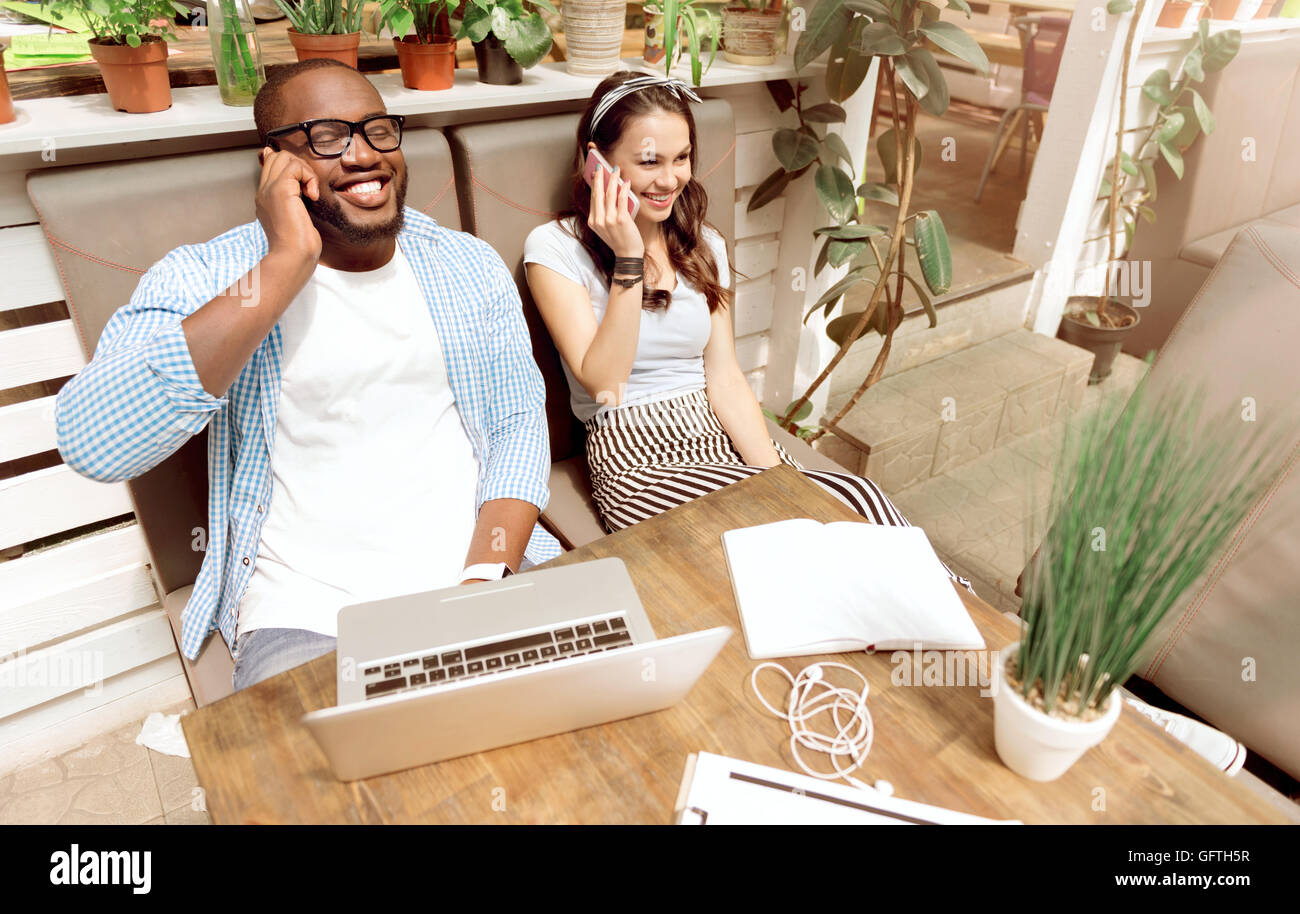 Cheerful colleagues talking on phones Stock Photo - Alamy