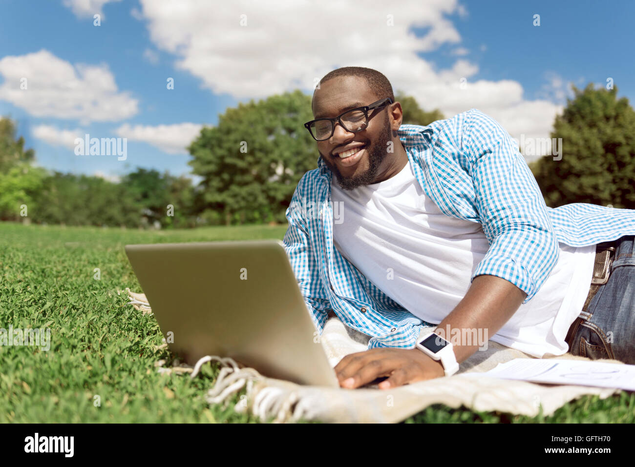 Positive smiling man using laptop Stock Photo - Alamy