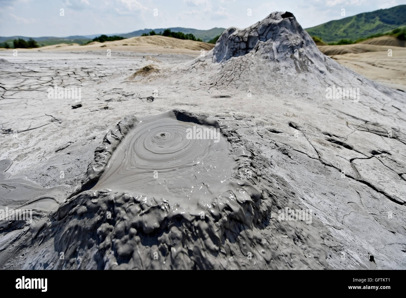 Mud volcanoes also known as mud domes erupting in summer landscape ...