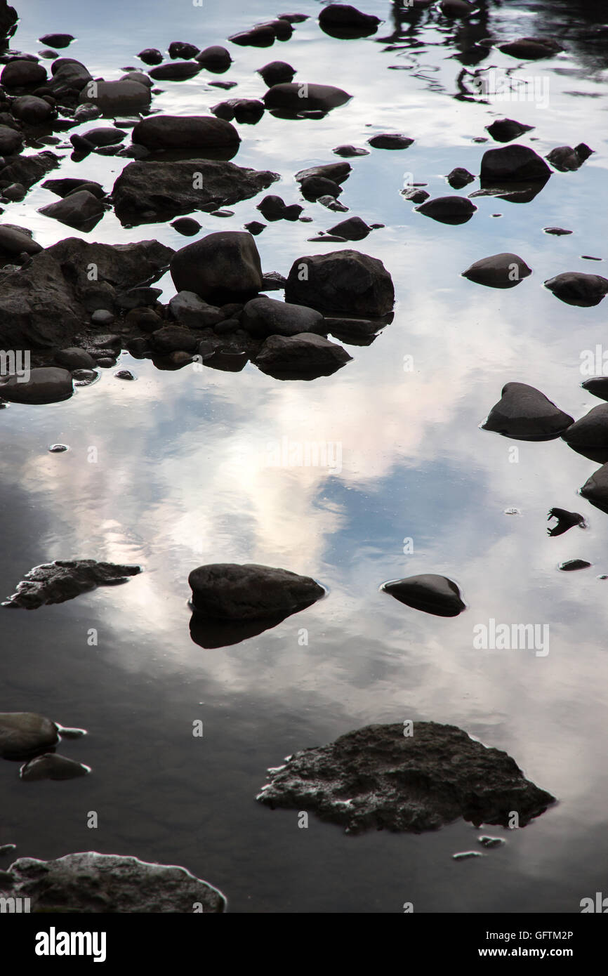 Sky reflection in the water with stones Stock Photo - Alamy