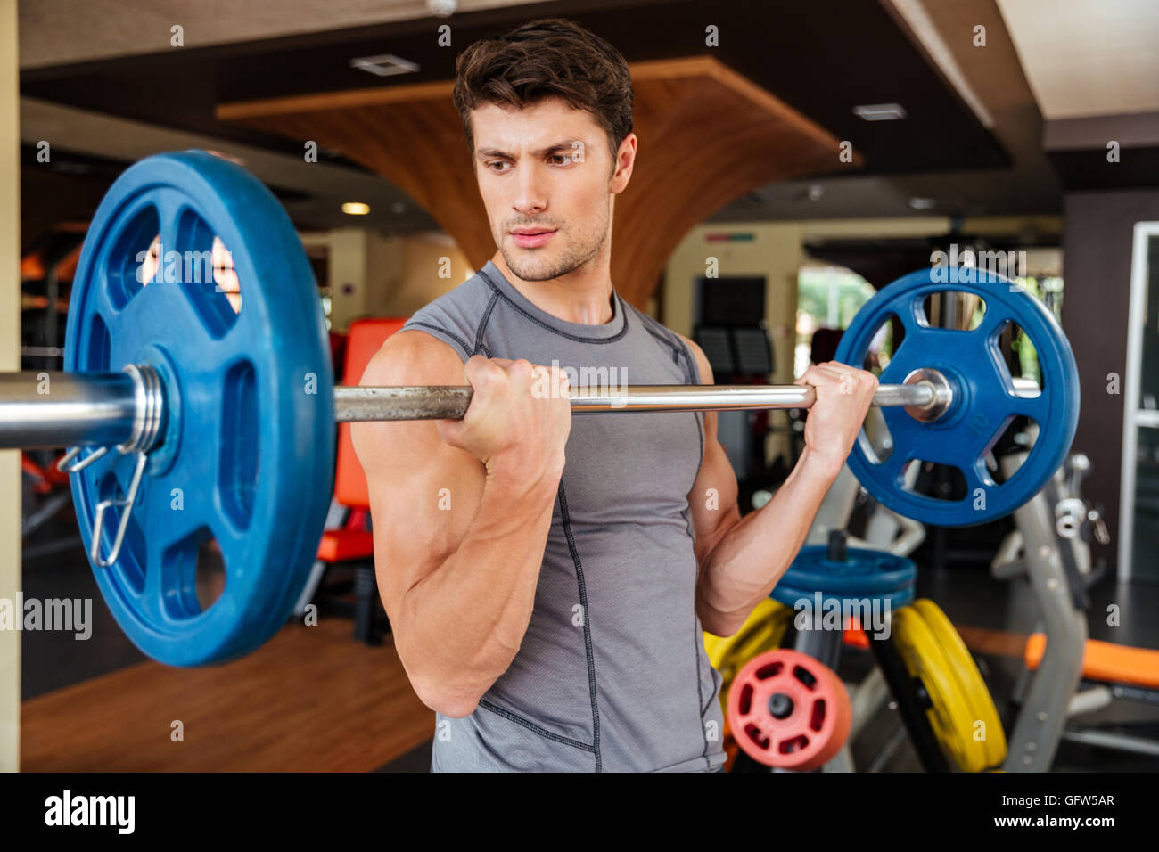 Handsome young man athlete working out with barbell in gym Stock Photo ...