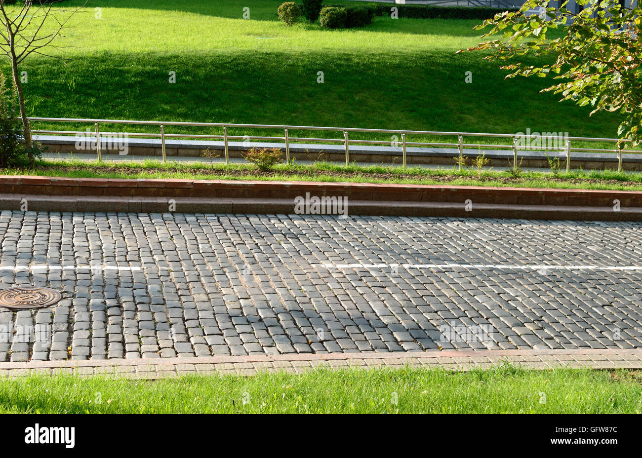 Paving stone road Green grass and sidewalk Stock Photo - Alamy