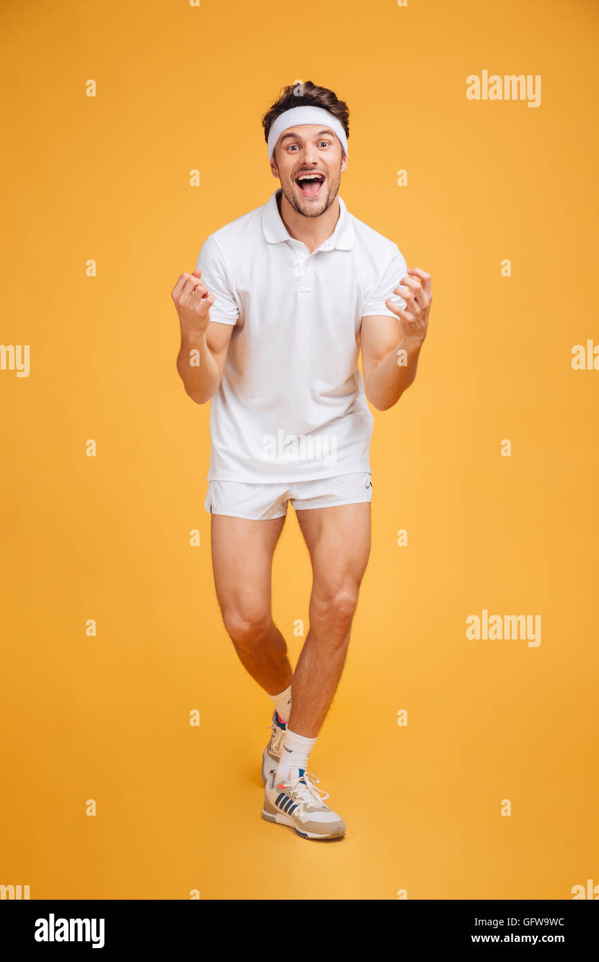 Happy excited young male athlete shouting and celebrating success over ...