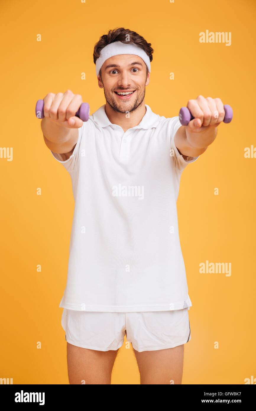 Portrait of happy young man athlete standing and working out with ...