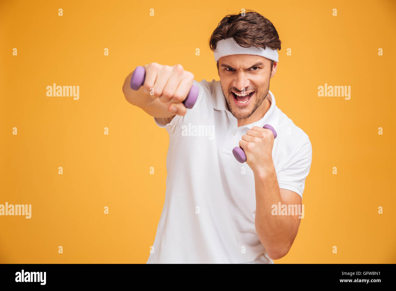 Handsome fitness man working out with small dumbbells isolated on a ...