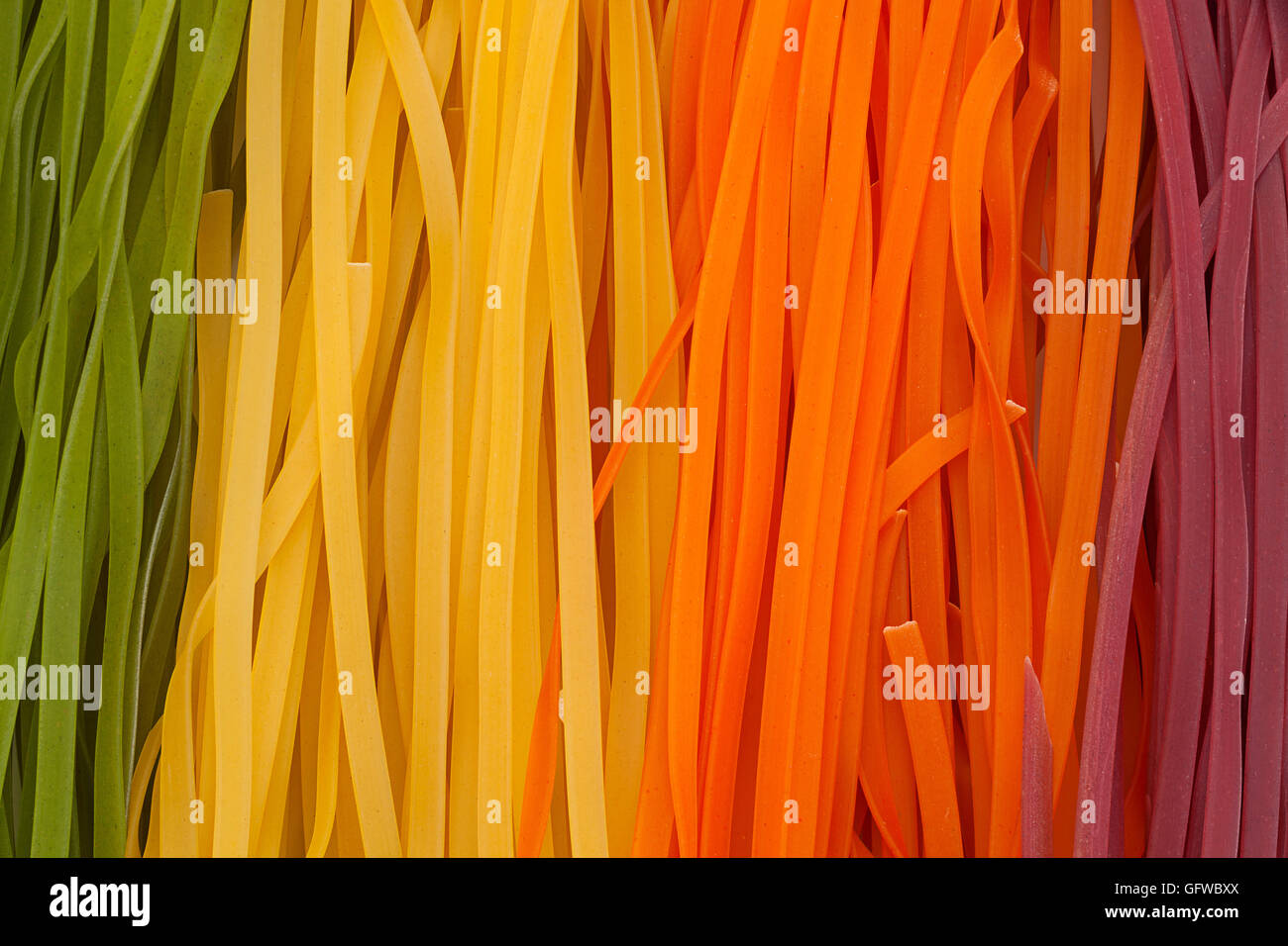 Wheat multicolored noodles closeup background Stock Photo - Alamy