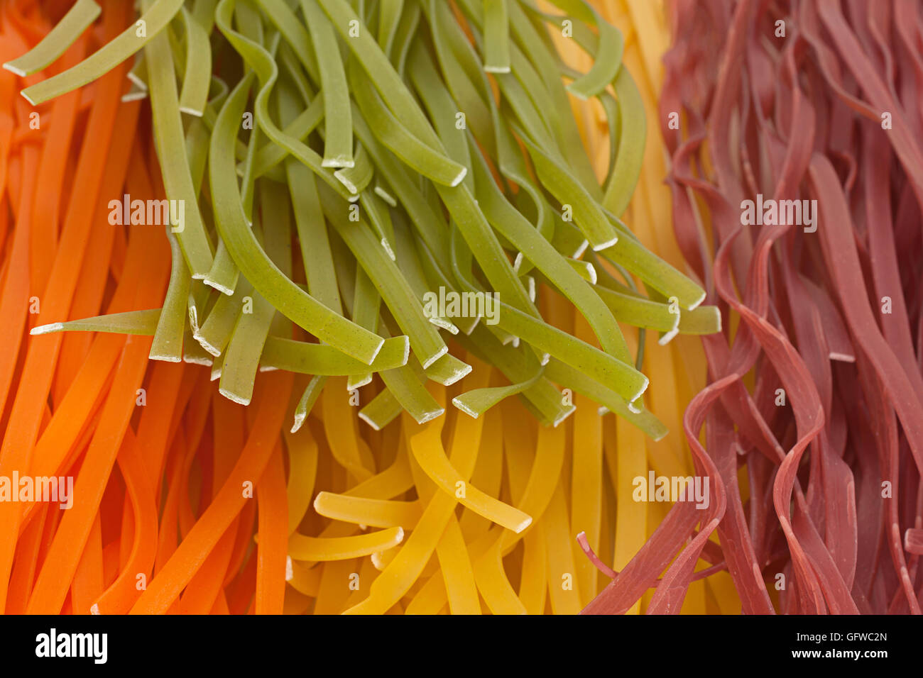 Wheat multicolored noodles closeup background Stock Photo - Alamy