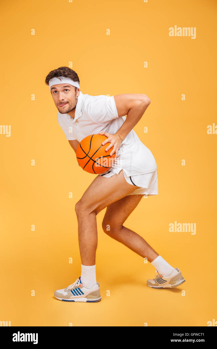 Portrait of a handsome young man playing basketball isolated on a ...