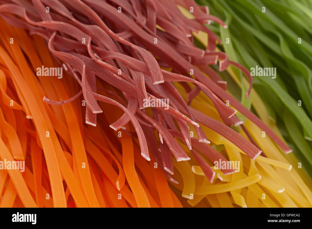 Wheat multicolored noodles closeup background Stock Photo - Alamy