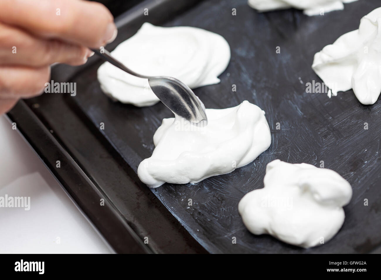 Placing and shaping meringues on a baking sheet Stock Photo - Alamy