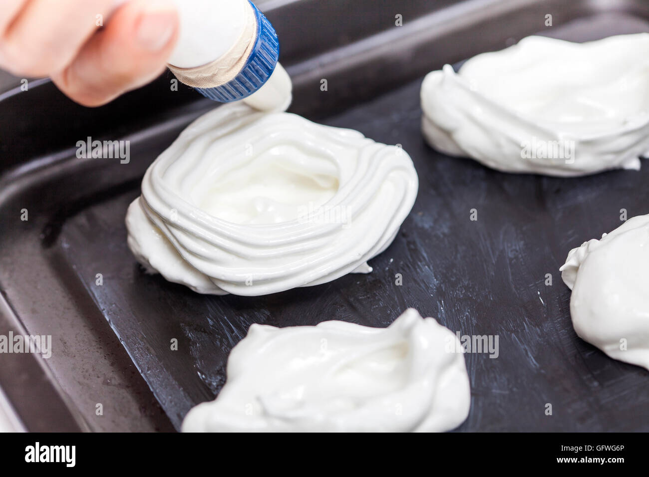 Placing and shaping meringues on a baking sheet Stock Photo - Alamy