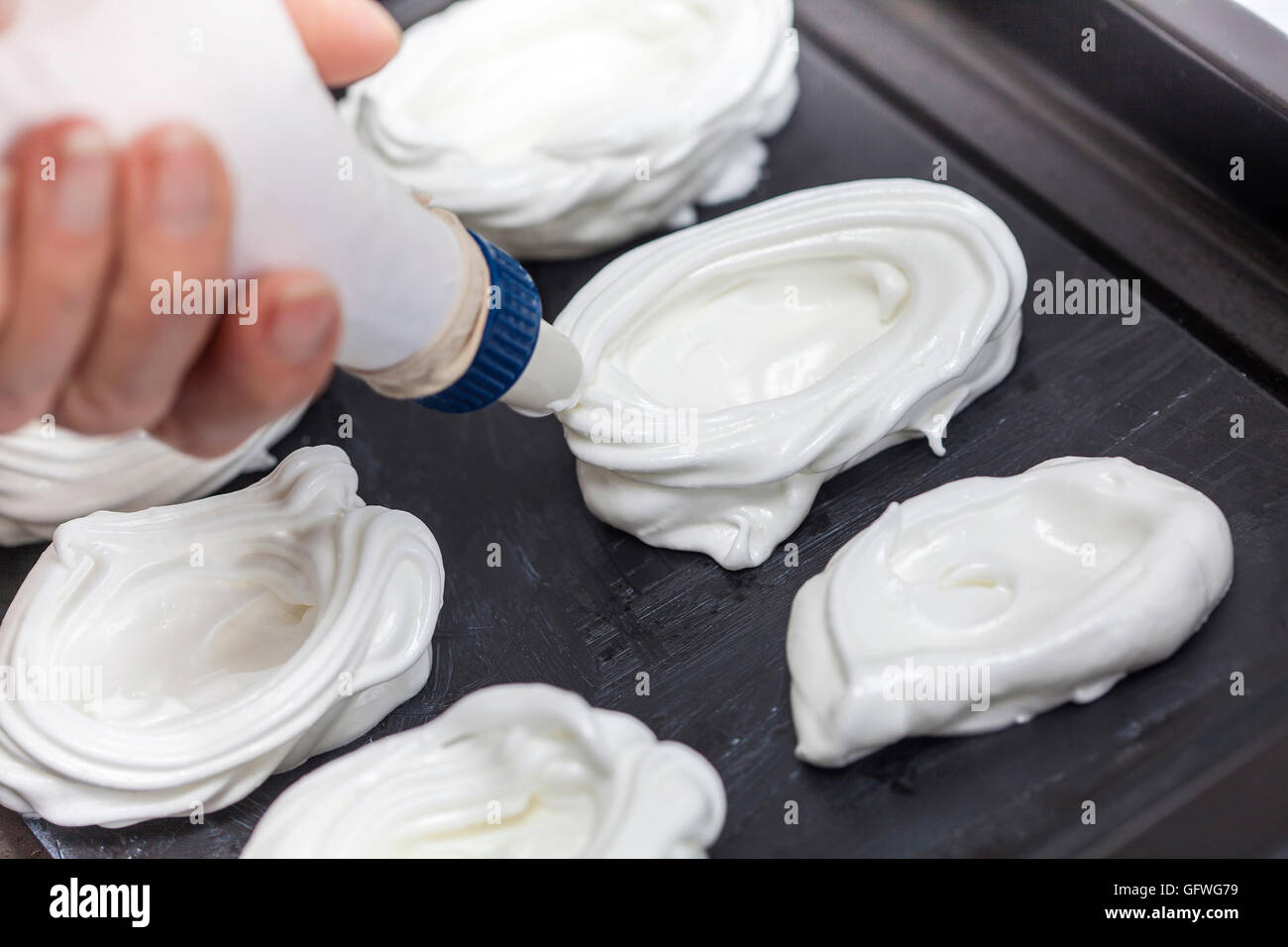 Placing and shaping meringues on a baking sheet Stock Photo - Alamy