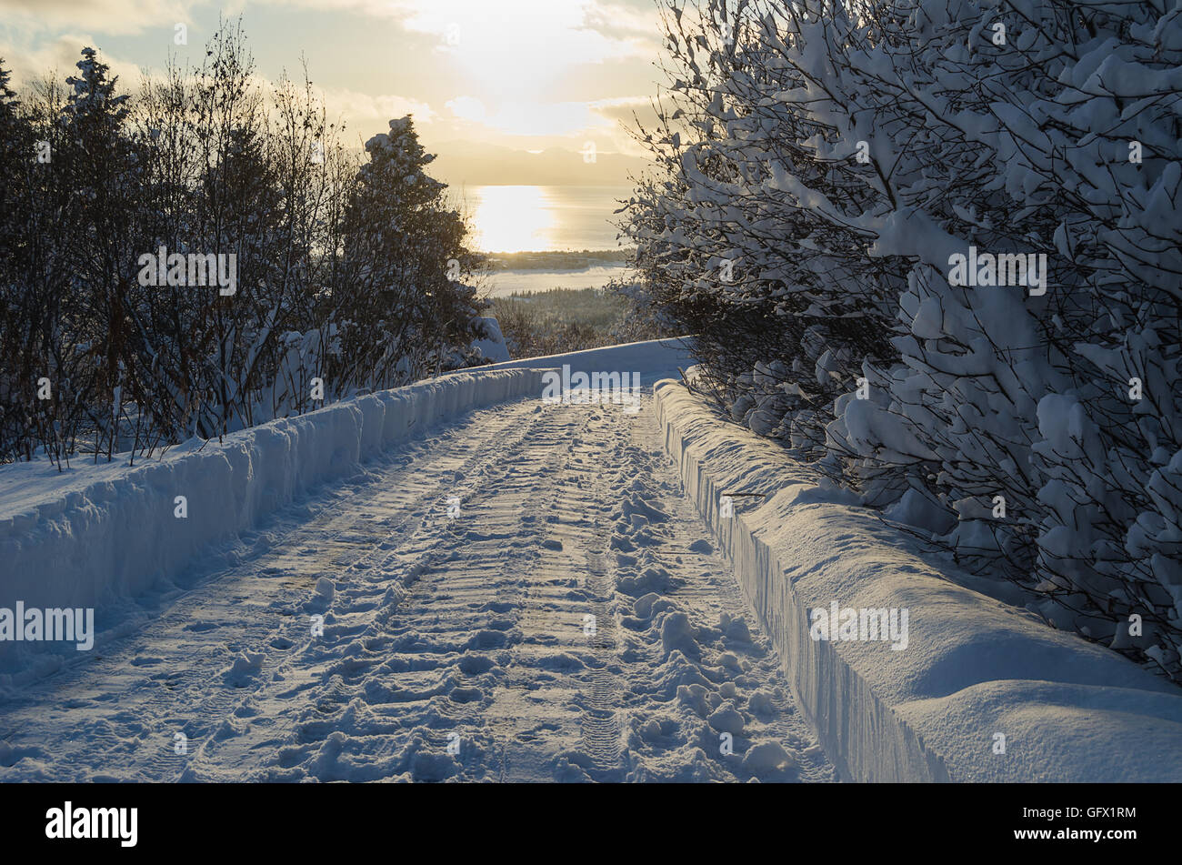 A freshly cleared driveway shows deep snow in a bright Alaskan winter ...