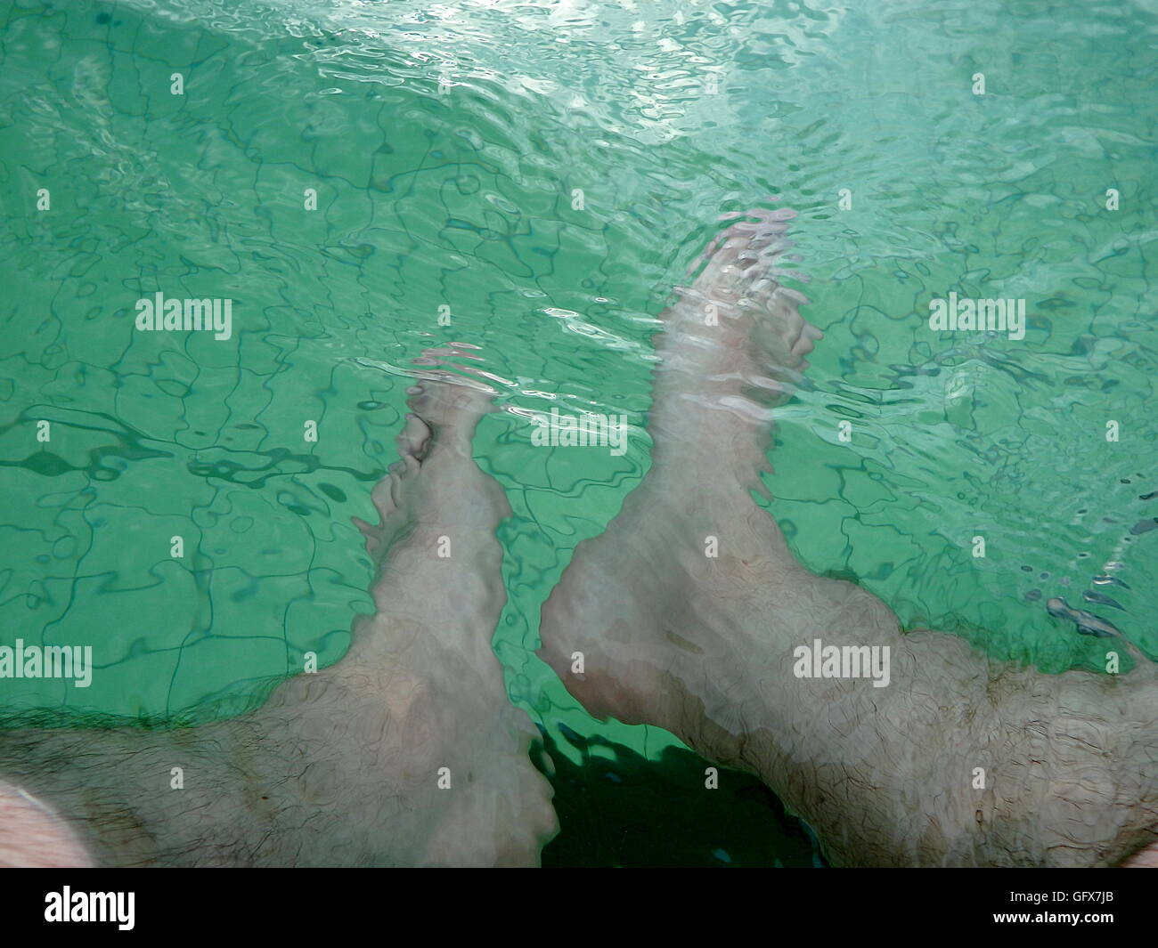 legs in the pool, feet in the clear water Stock Photo - Alamy