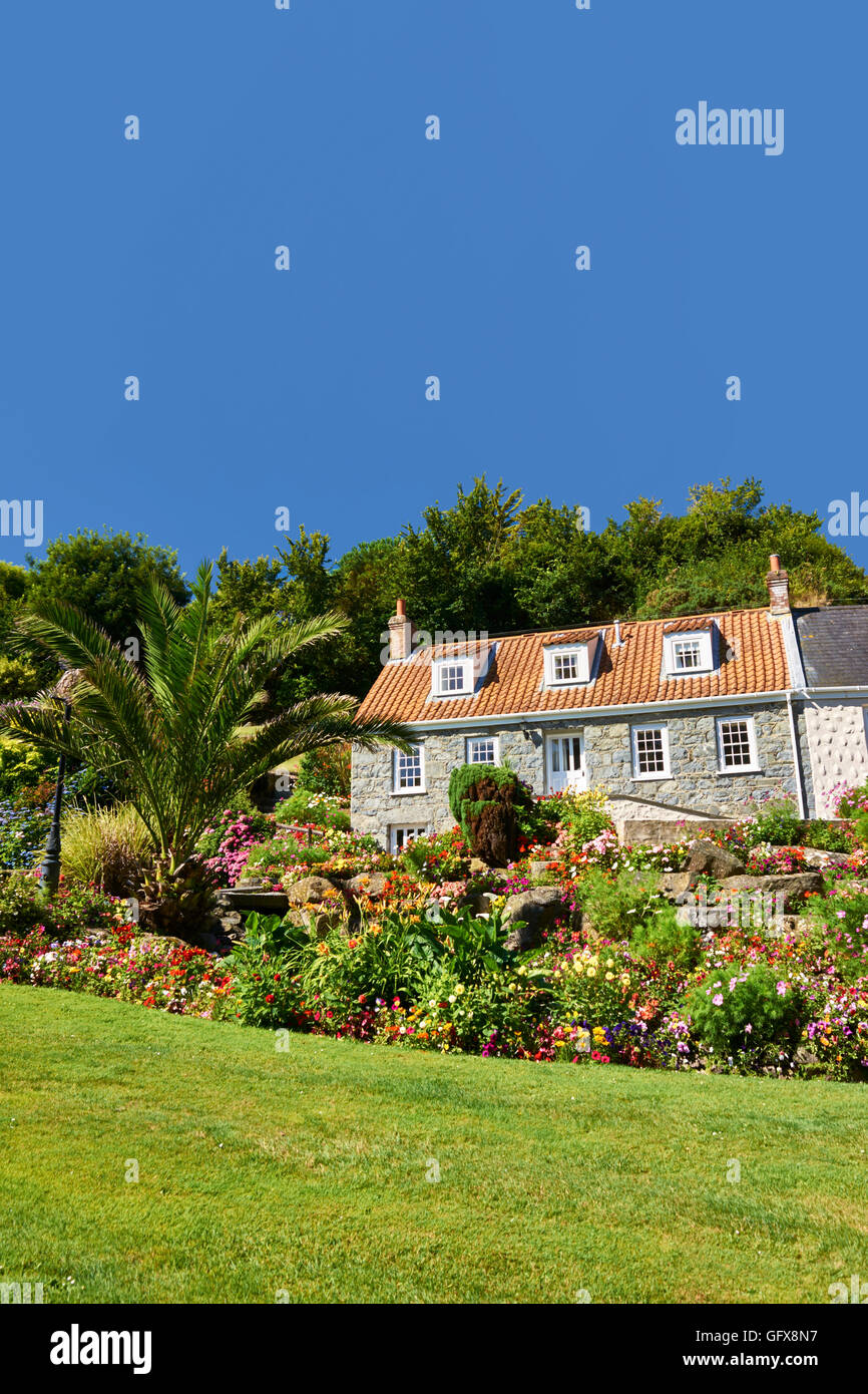 Cottage flower beds and lawn against blue sky Stock Photo - Alamy