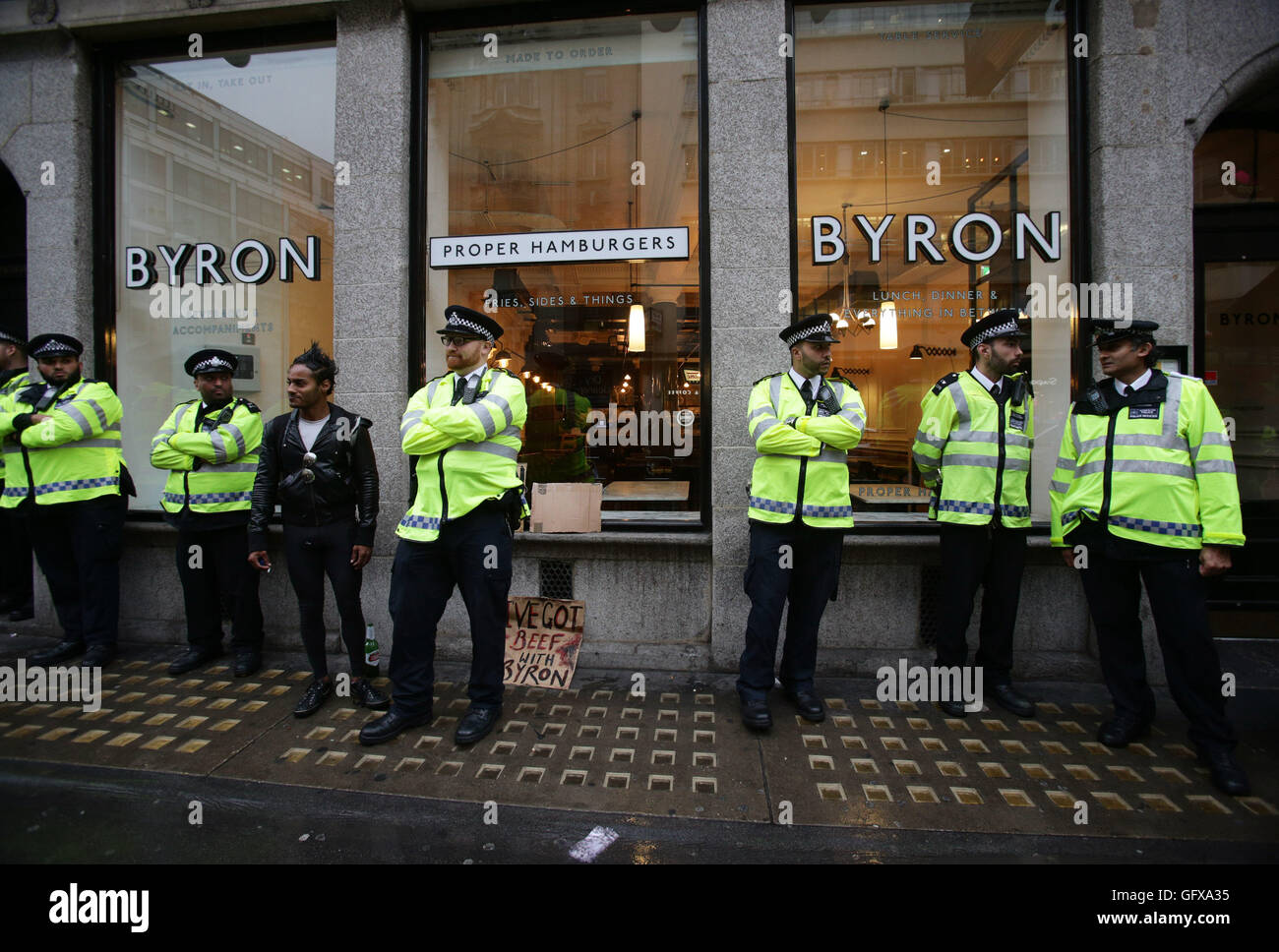 Police officers stand outside a Byron restaurant in Holborn, central ...