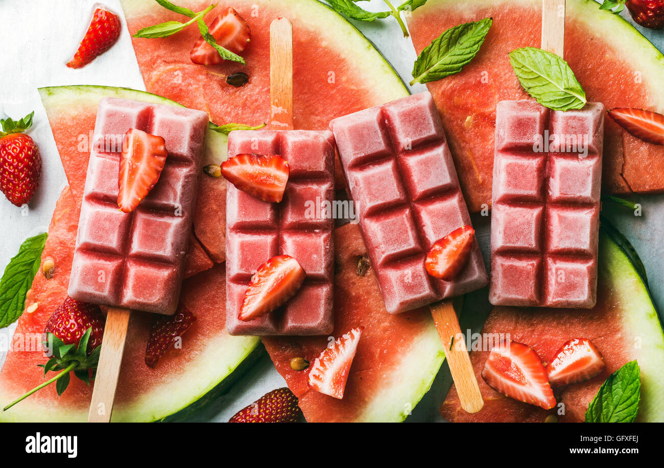 Strawberry watermelon ice cream popsicles with mint over steel tray ...