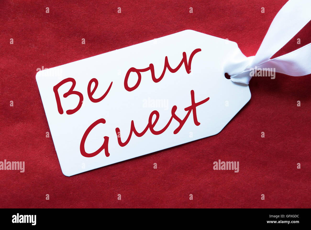 One Label On Red Background, Text Be Our Guest Stock Photo - Alamy