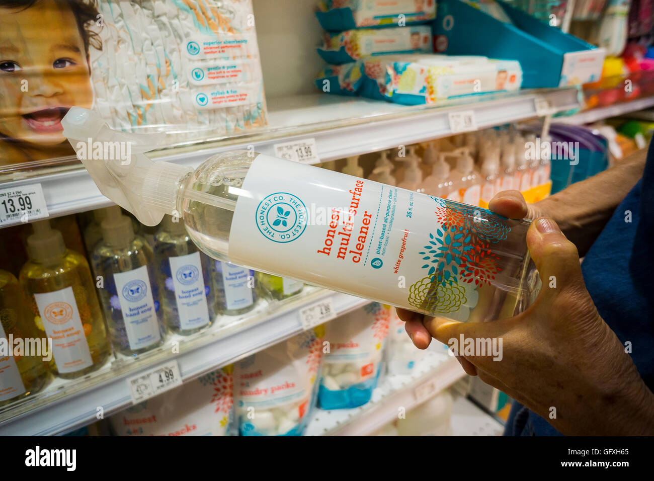 A shopper with The Honest Co. cleaners in a health and beauty aid store ...