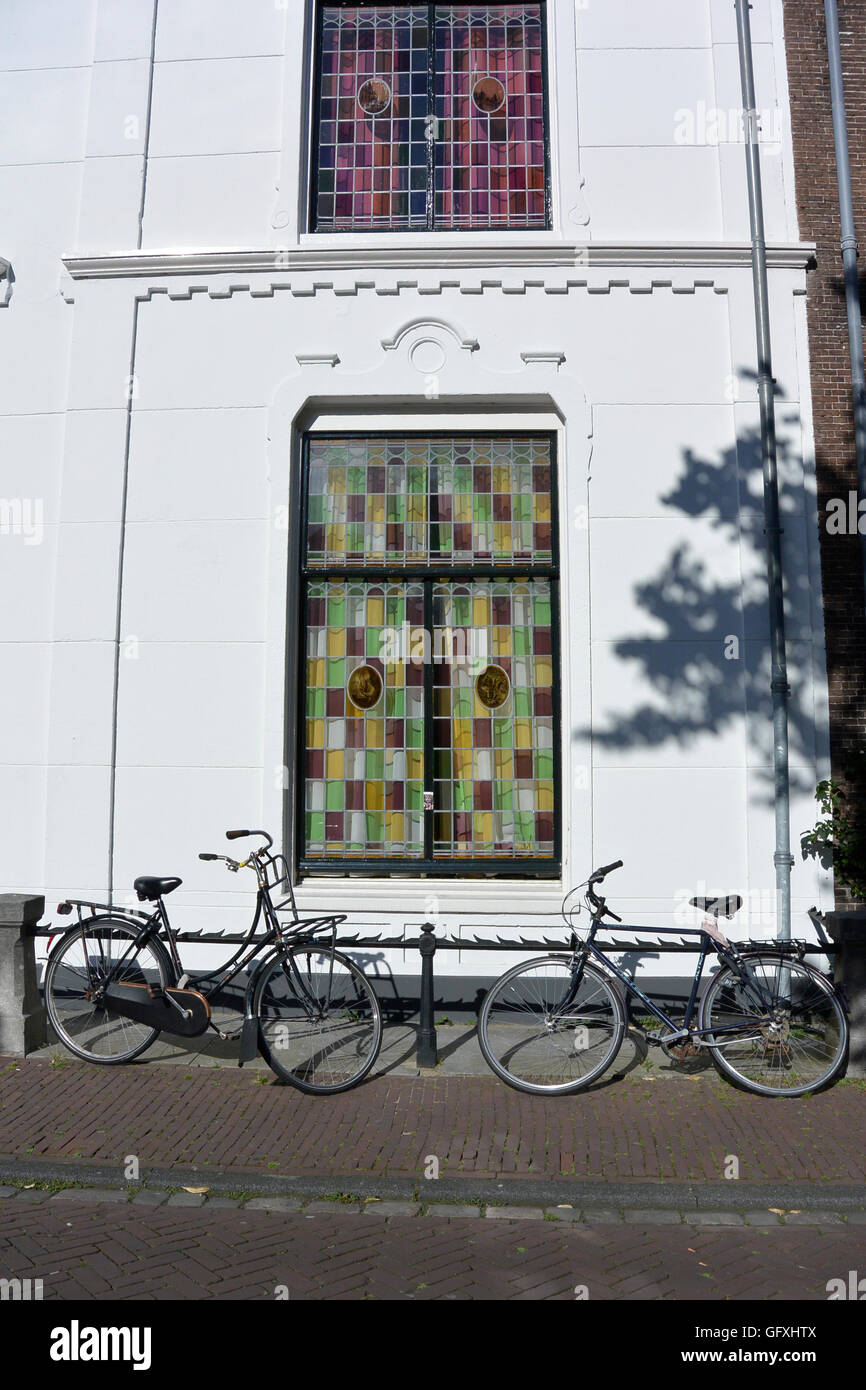 Dutch bicycles outside a window on a busy street where the stained ...