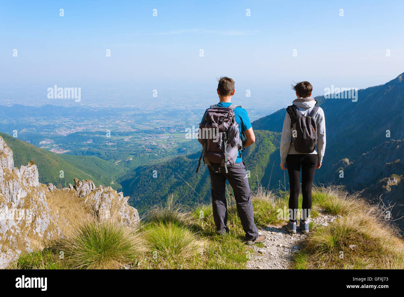 Young couple on top of mountain looking at the horizon. Mountain ...