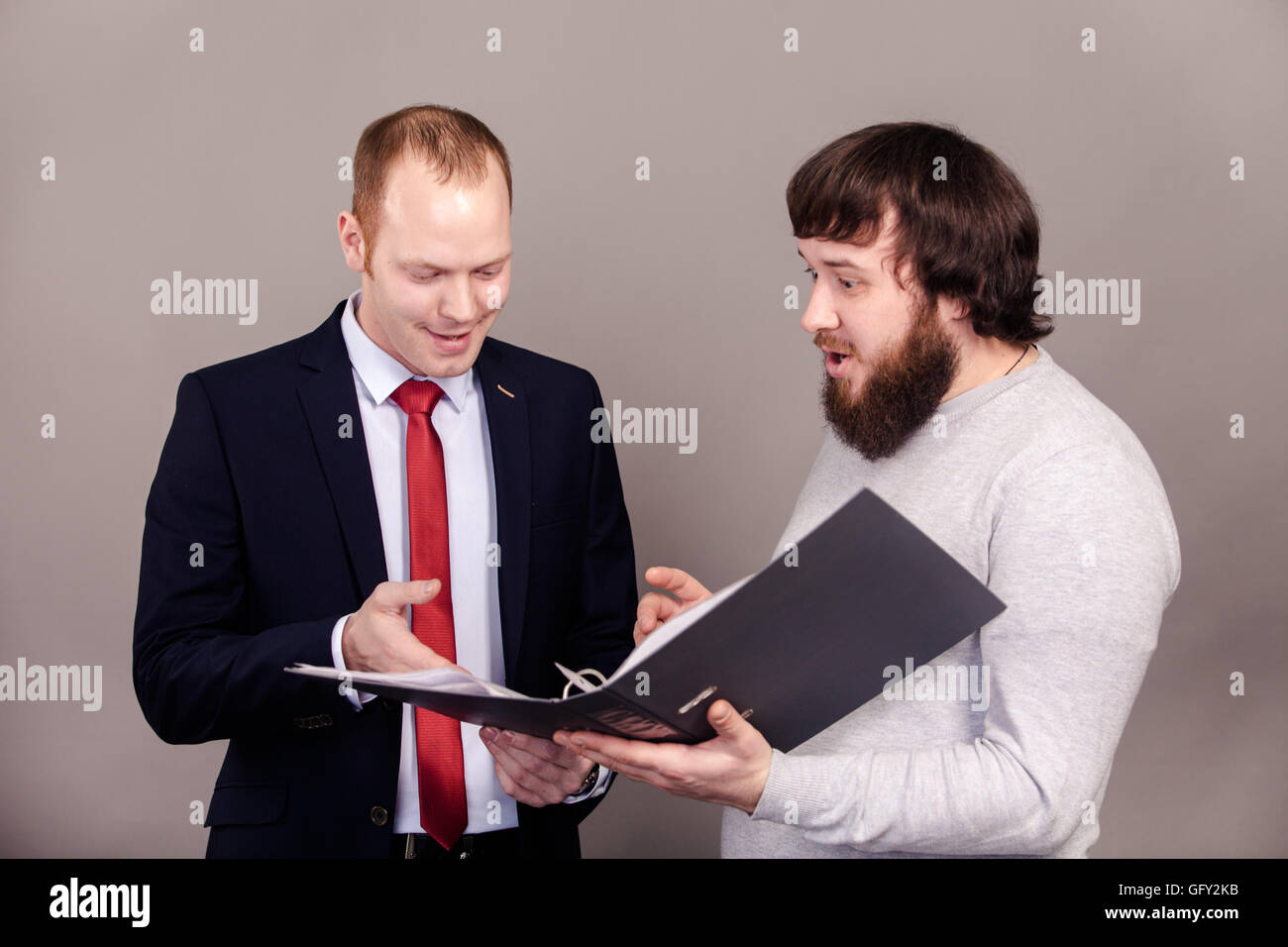Two business people in elegant suits sitting at desk working in team ...