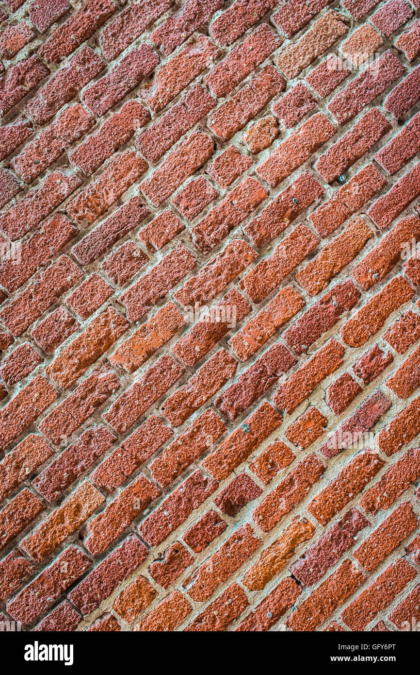 Red brick masonry forms wall at angle to ground Stock Photo - Alamy