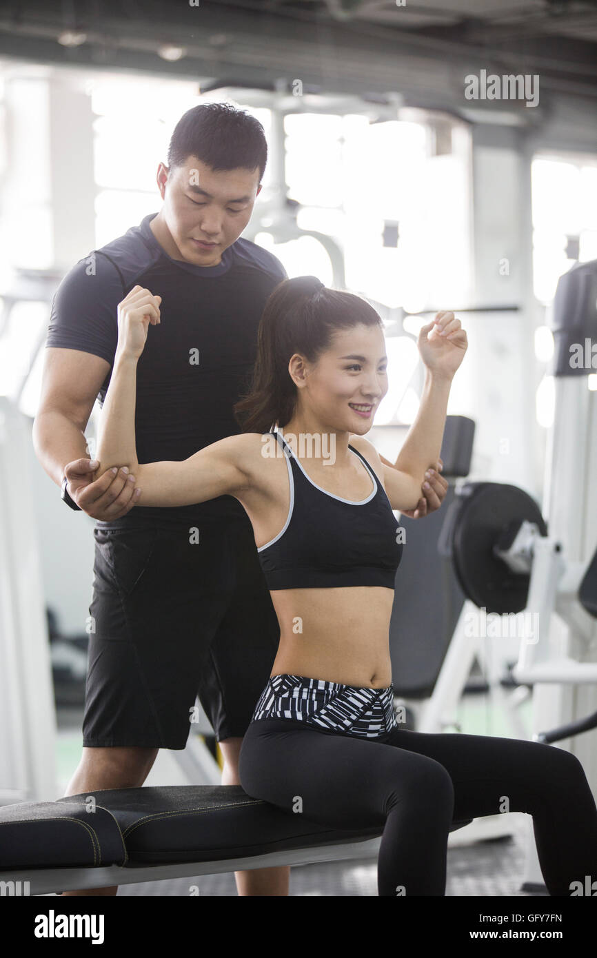 Young Chinese woman working with trainer at gym Stock Photo - Alamy