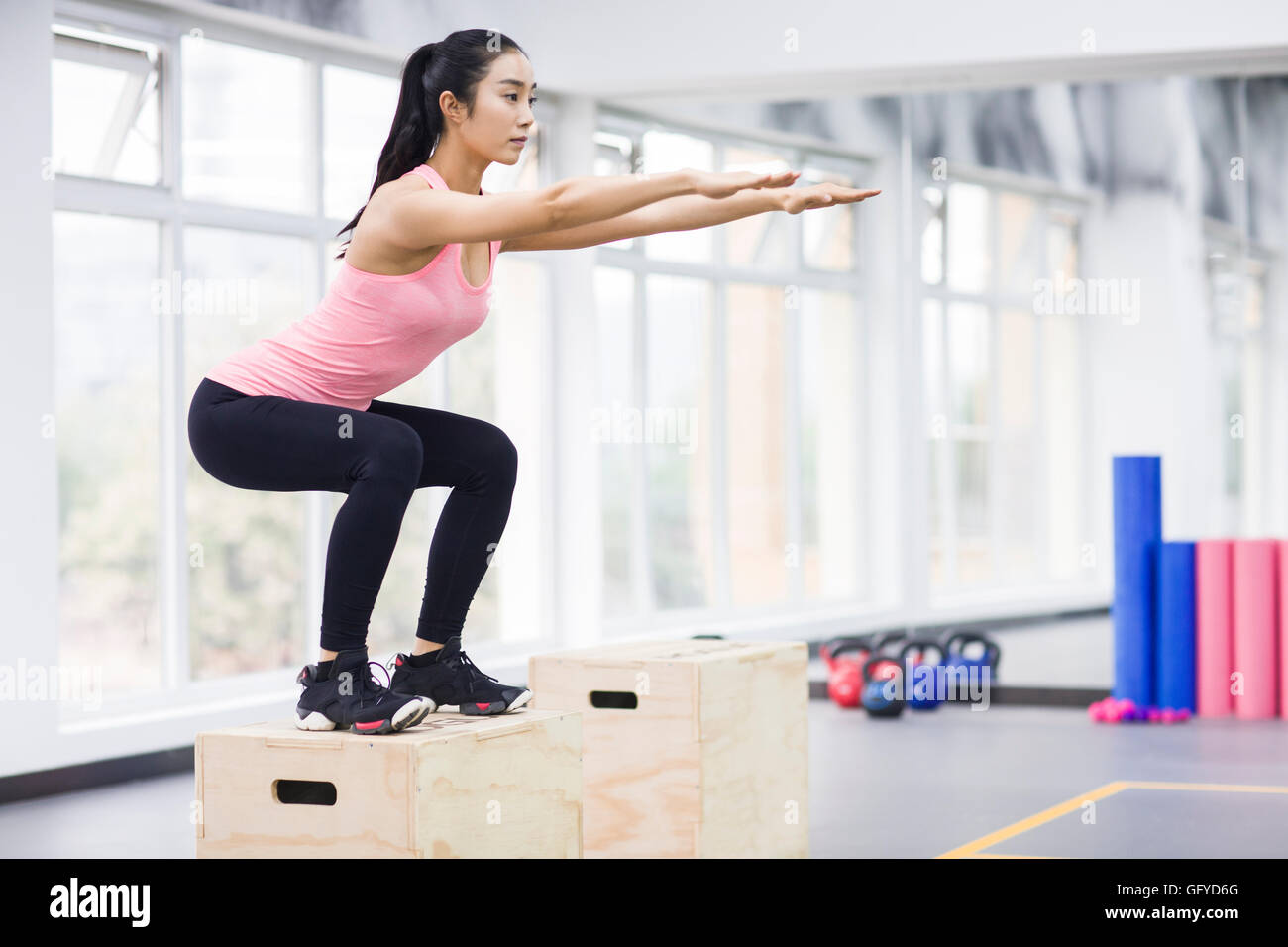Young Chinese woman doing box jump in crossfit gym Stock Photo - Alamy