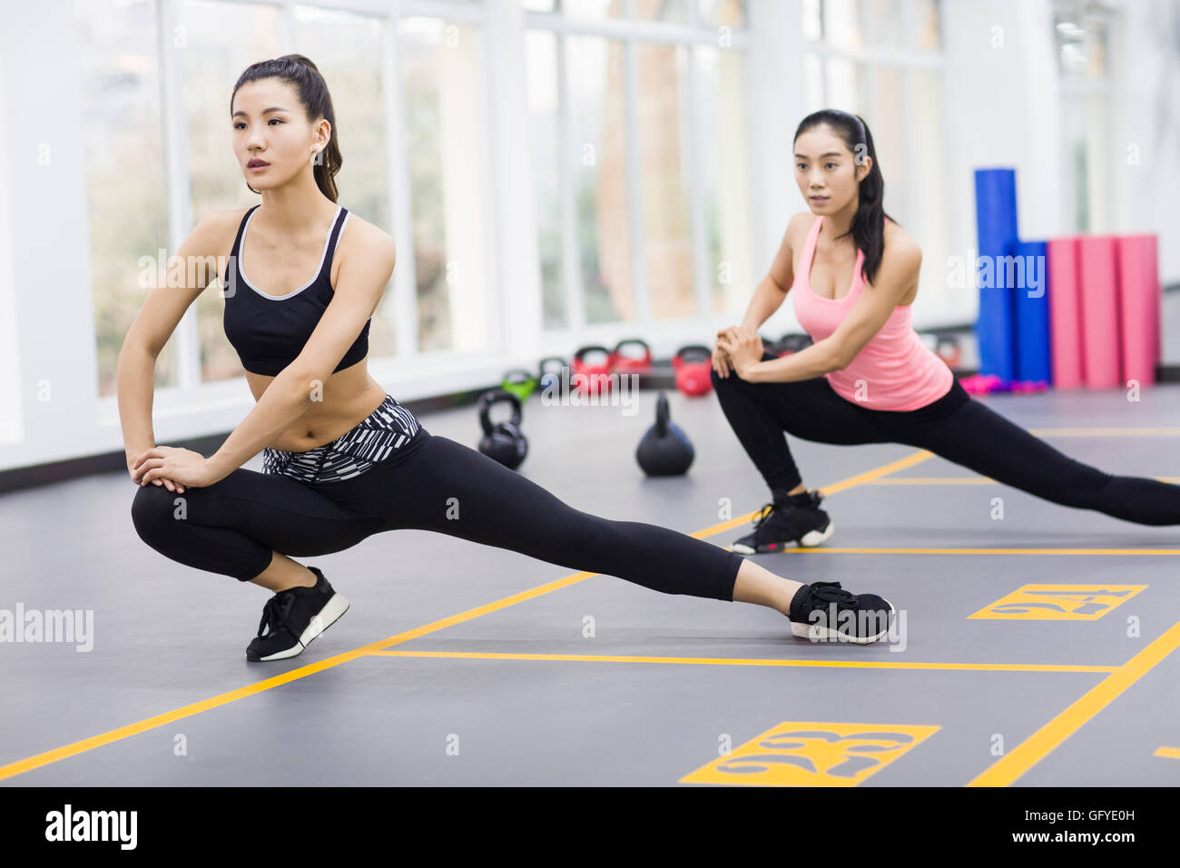 Young Chinese woman working with trainer at gym Stock Photo - Alamy