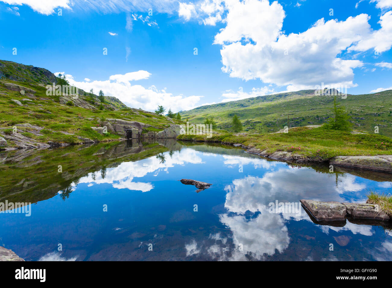 Italian mountain panorama, clouds reflected on alpine lake. Trekking ...