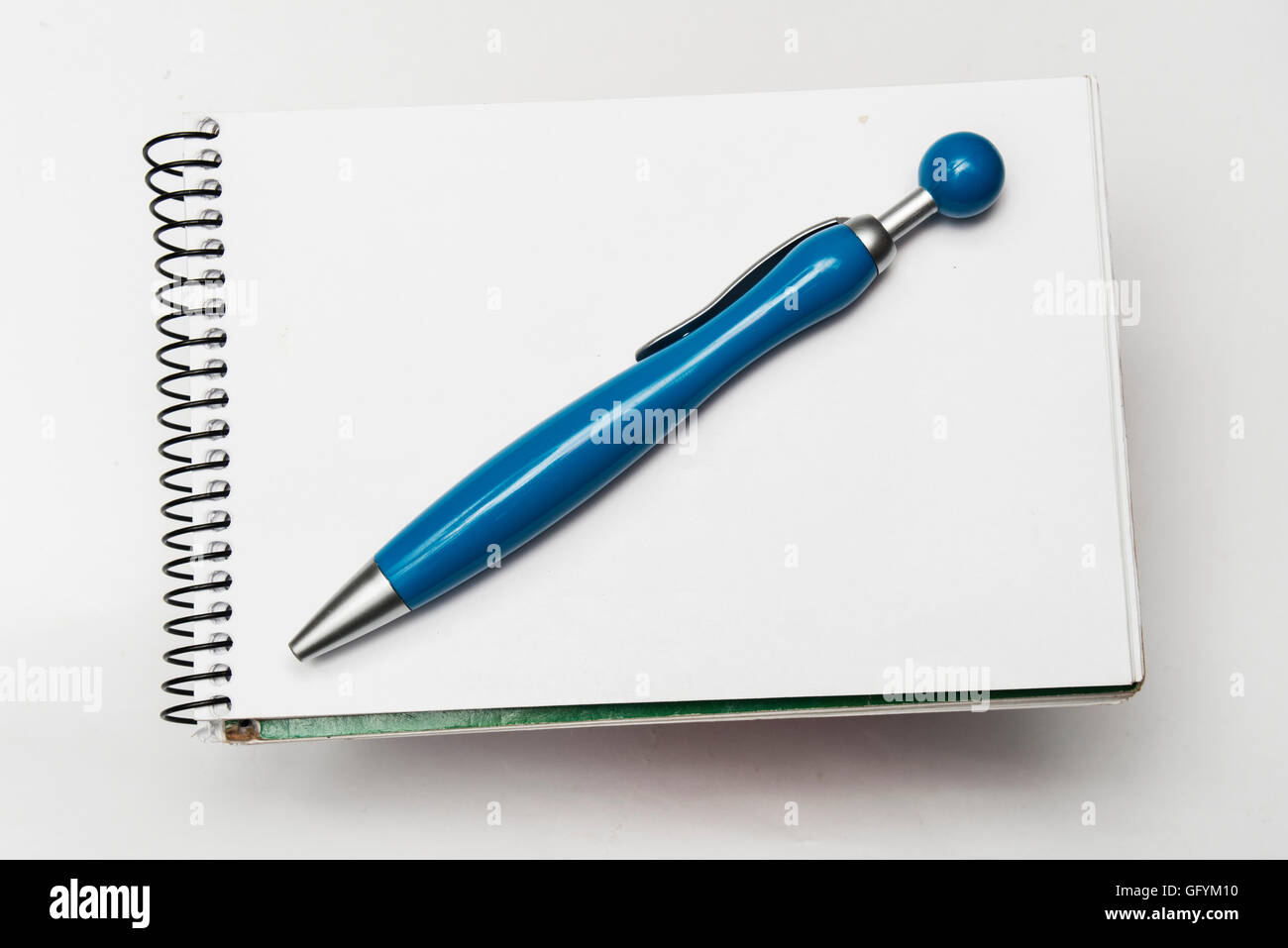 blue pen on notebook on white background Stock Photo - Alamy
