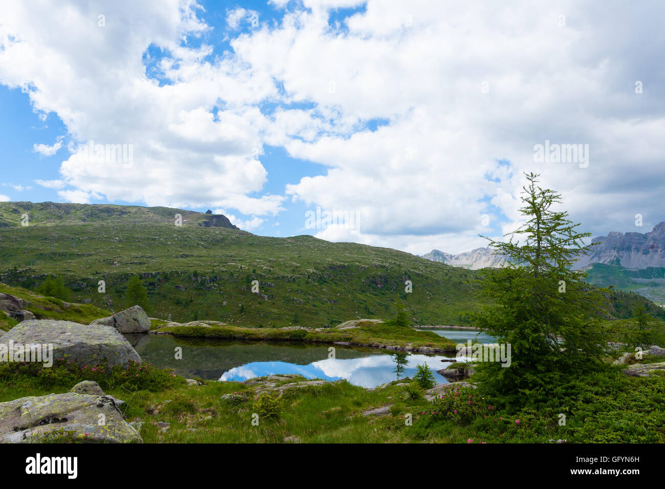 Italian mountain panorama, clouds reflected on alpine lake. Trekking ...