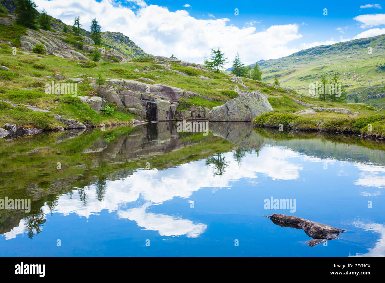 Italian mountain panorama, clouds reflected on alpine lake. Trekking ...