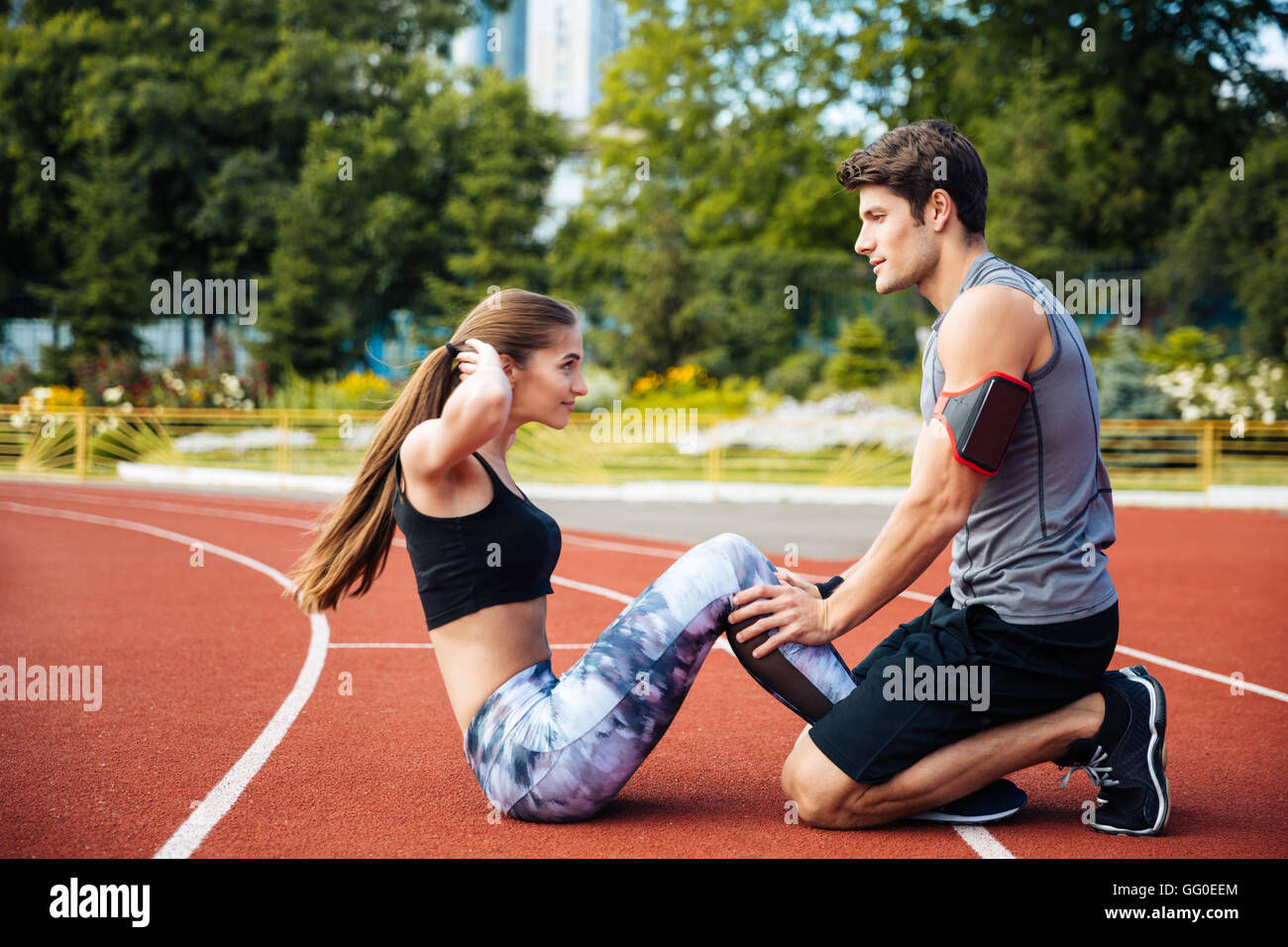 Young beautiful couple doing sports exercises at the stadium Stock ...