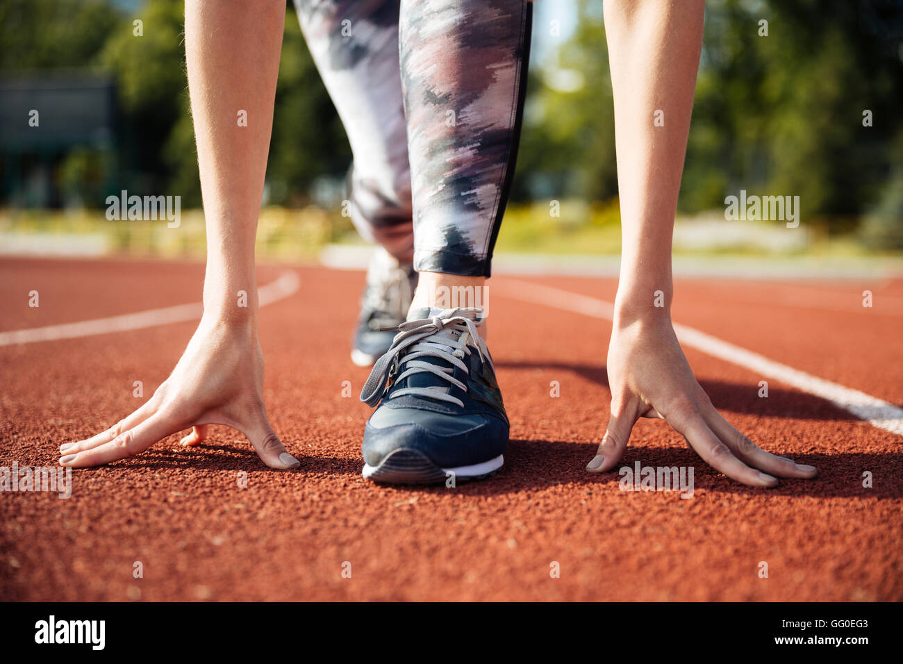 Cropped image of a female sprinter getting ready to start running at ... Cropped image of a female sprinter getting ready to start running at ...