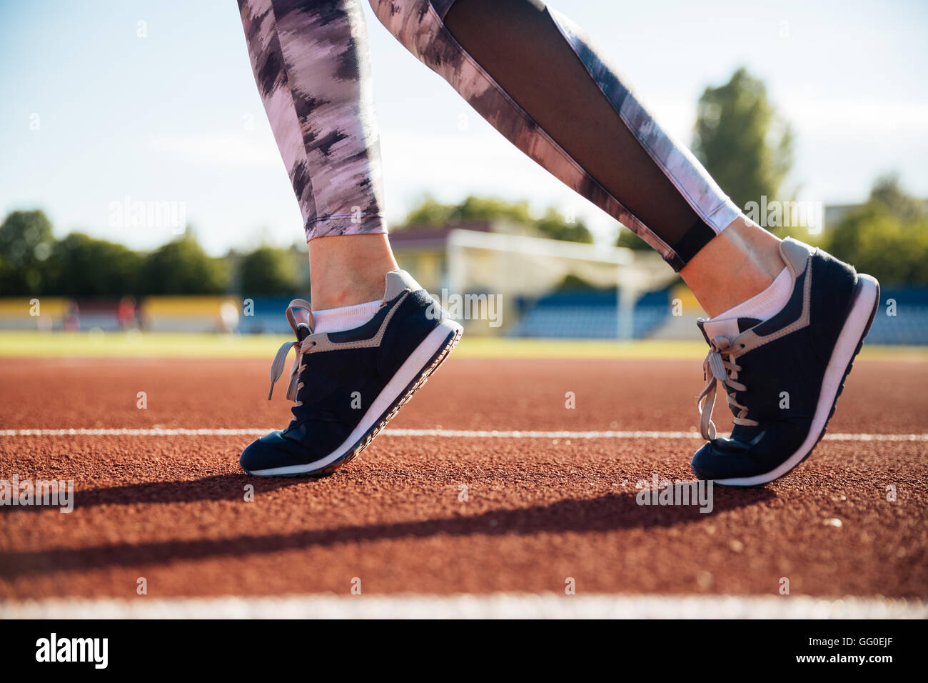 Close up portrait of a female runner feet running on stadium outdoors ...