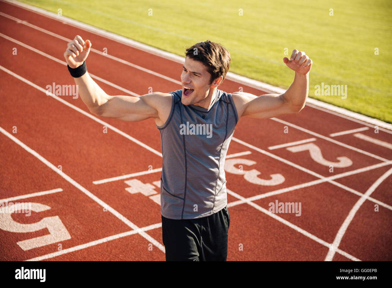 Cheerful sportsman celebrating his victory at a stadium Stock Photo - Alamy