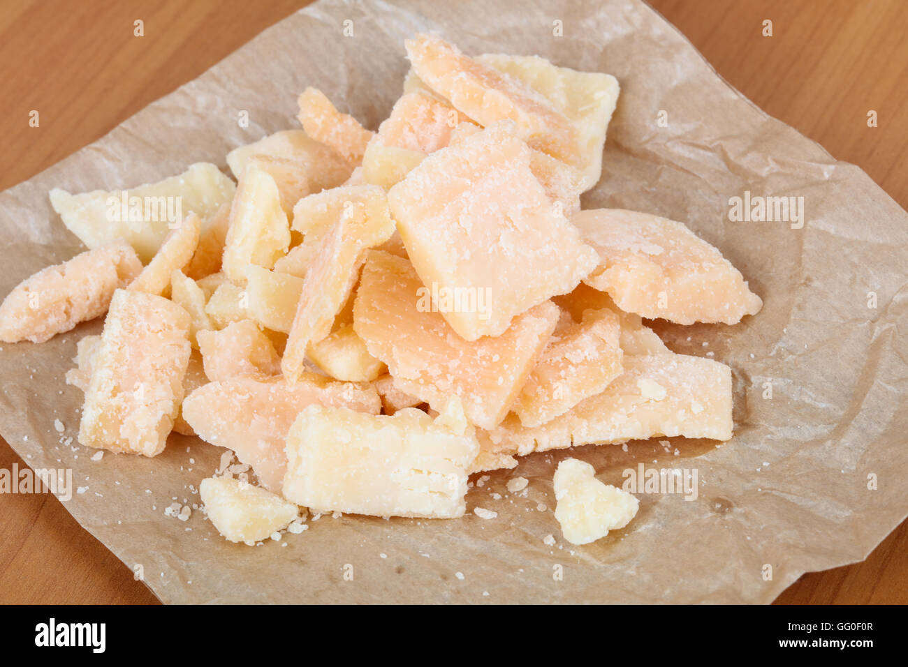 Cutting parmesan cheese crunches on the wood background Stock Photo - Alamy