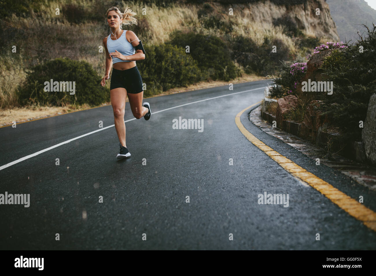 Full length shot of young fitness woman running outdoors on an open ...