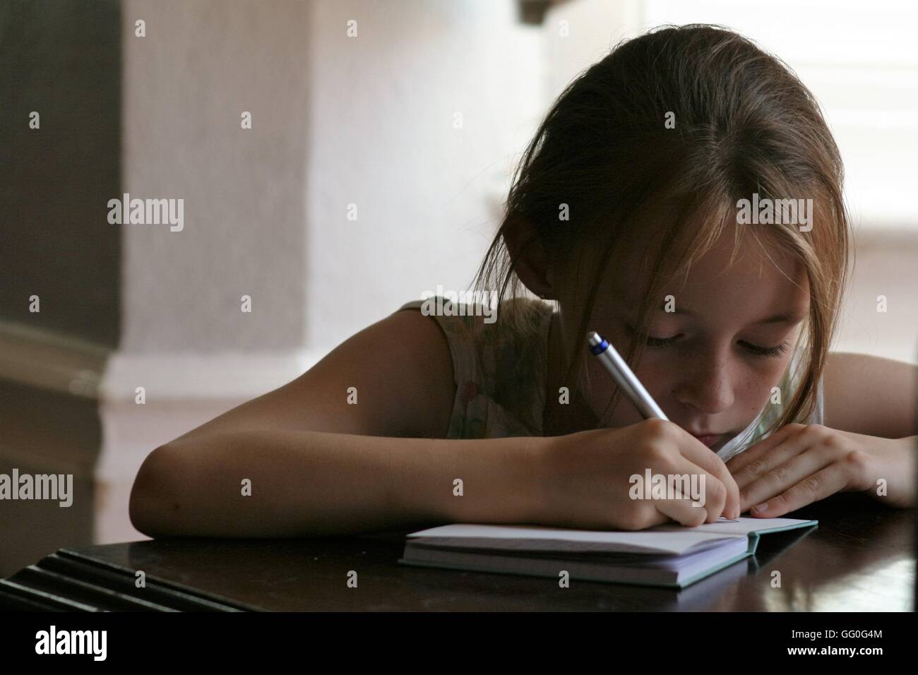 young girl writing in a book Stock Photo - Alamy