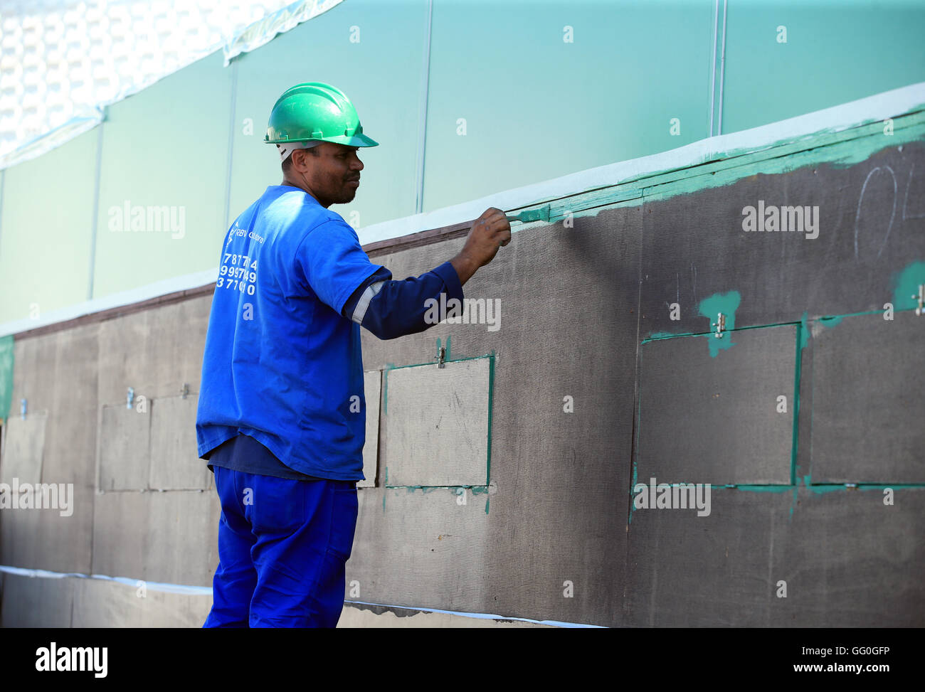 Workmen put the finishing touches of paint on the Beach Volleyball ...
