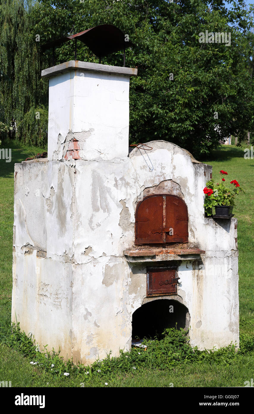 Rustic hundred years old hungarian furnace against green natural ...