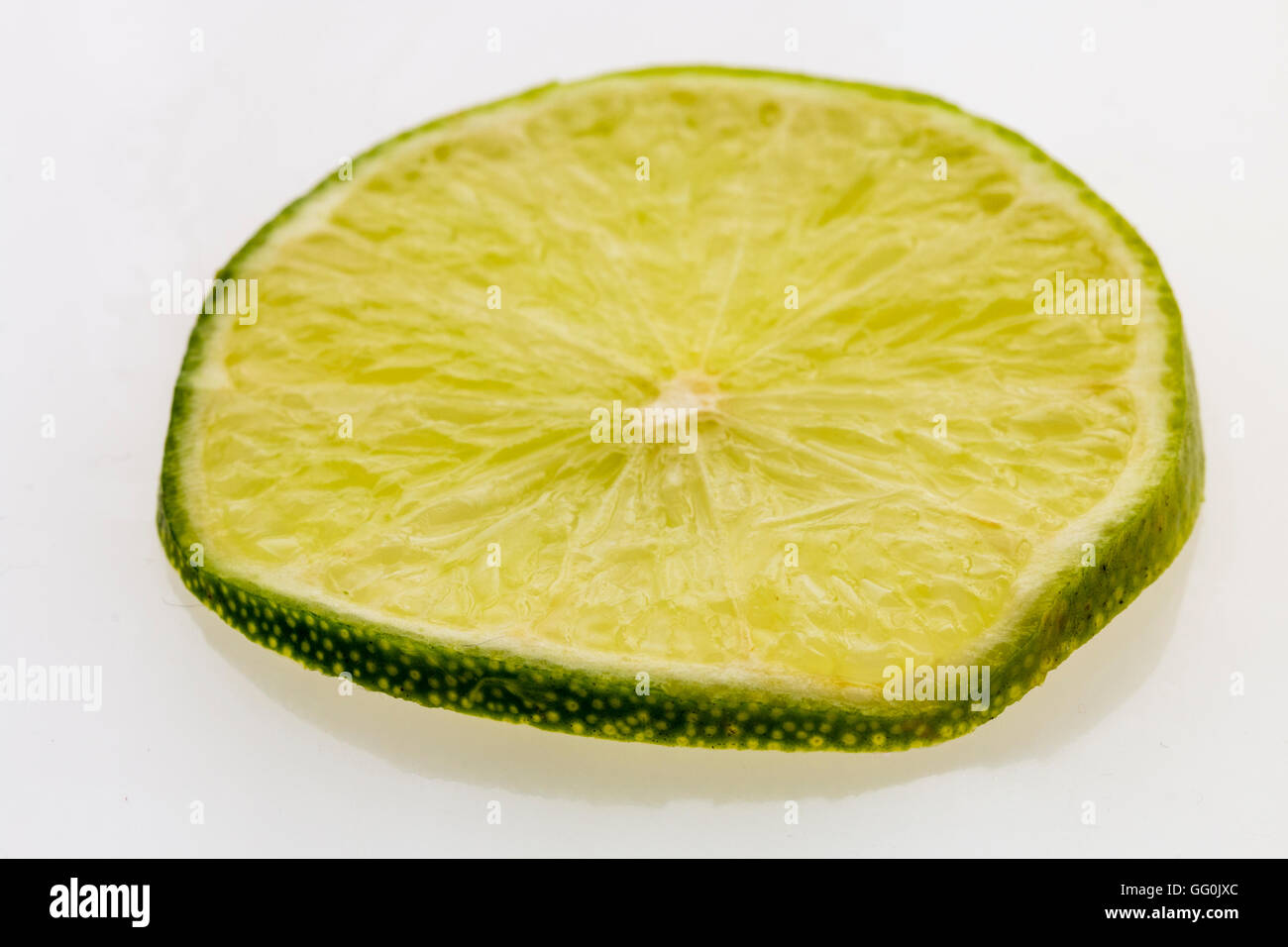Lime fruit. Single slice of lime fruit, top lit. Plain white background ...