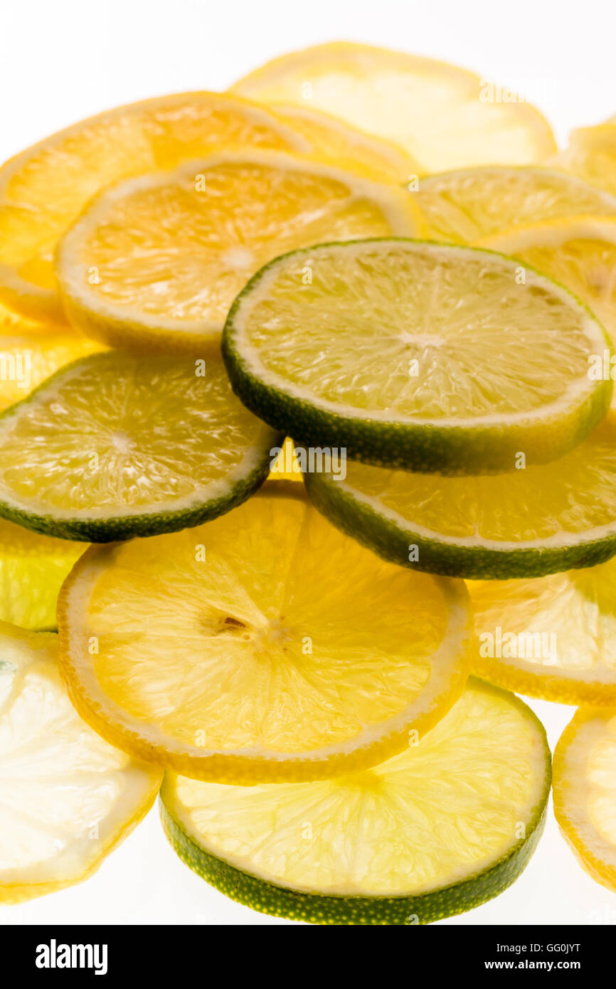 Lemon and lime fruit. Slices of both, mixed, stacked haphazardly. Back ...