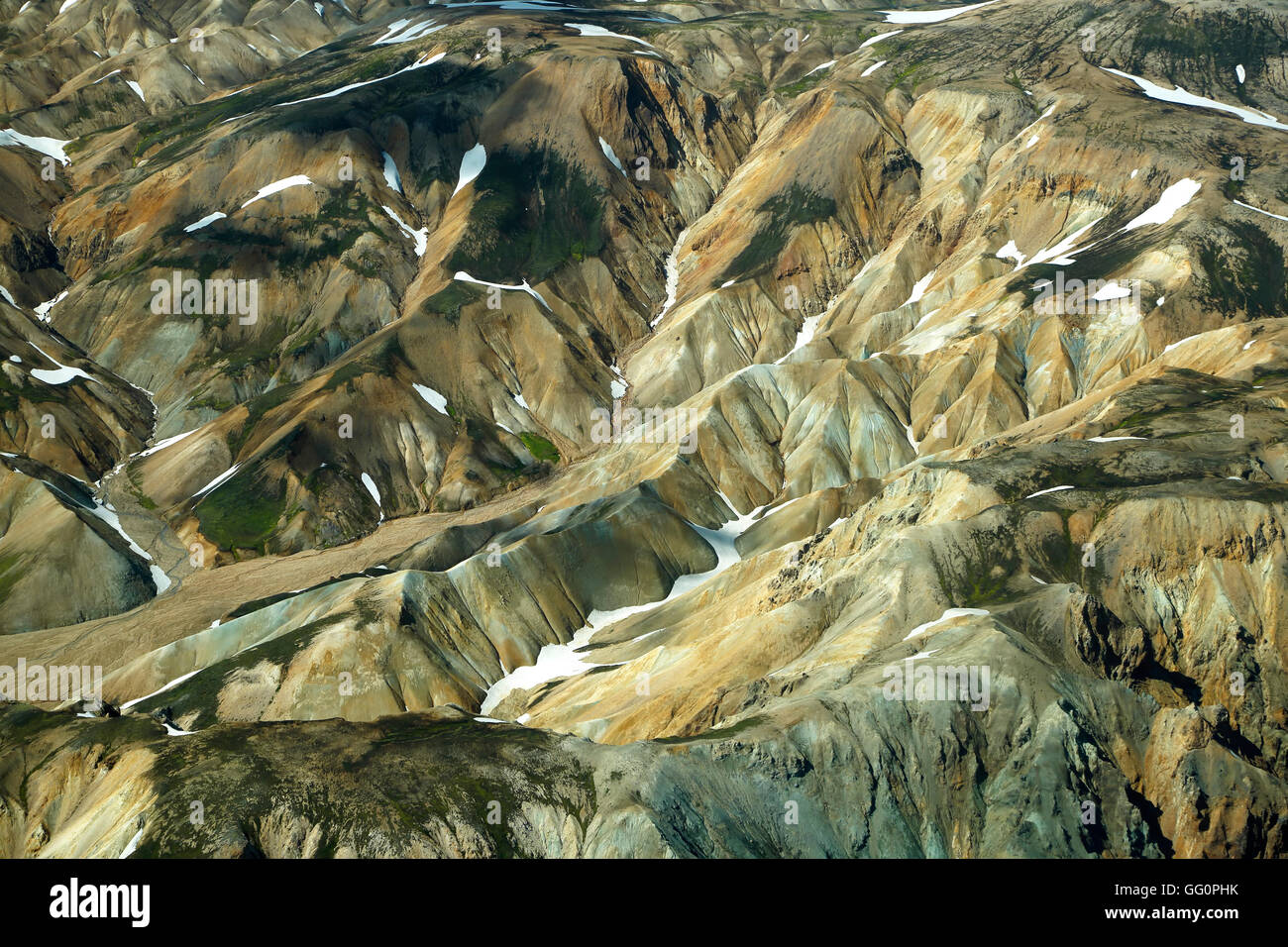 Aerial view of rhyolite mountains partially covered in snow ...
