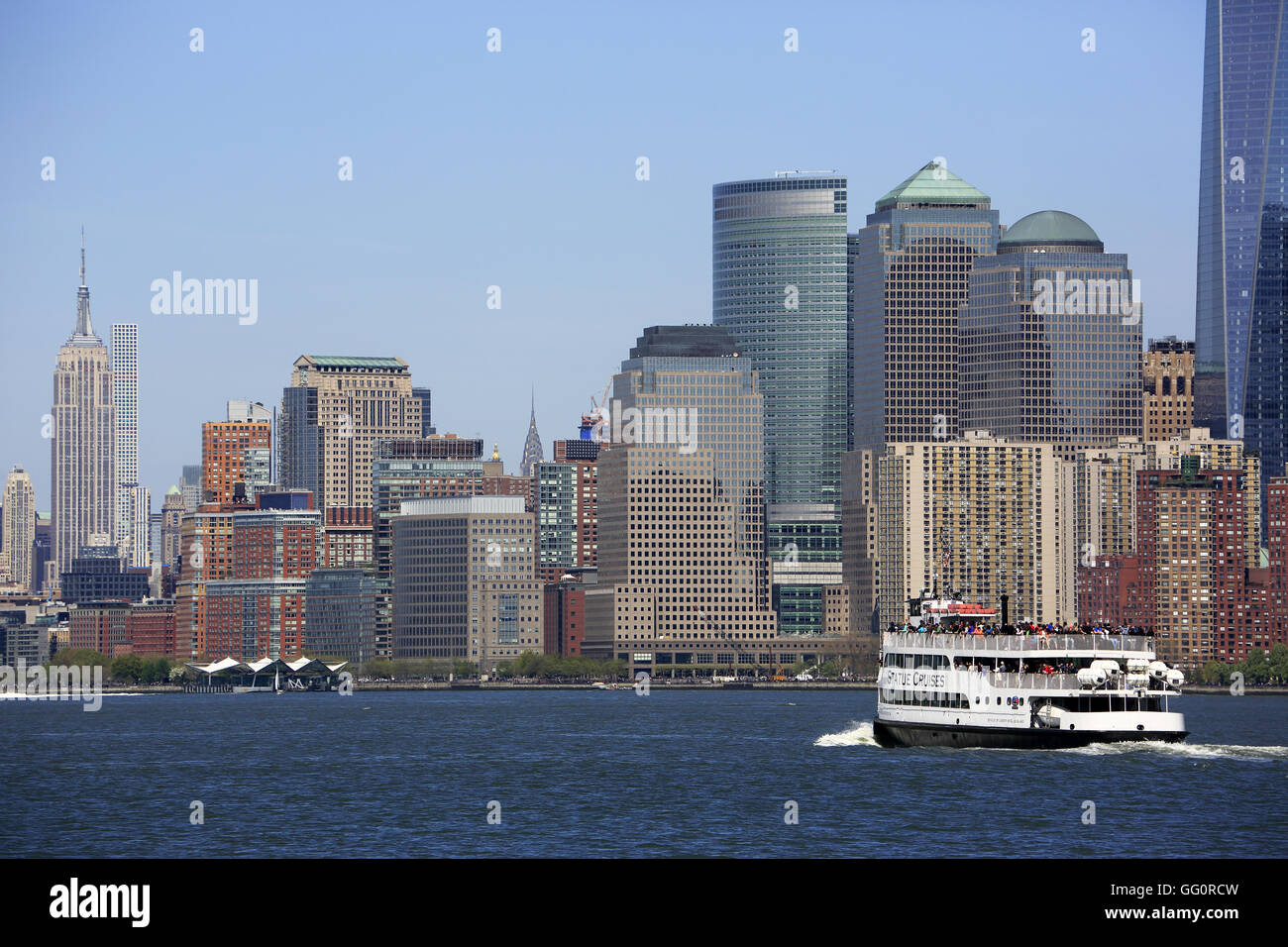 A ferry in waterfront of New York city with skyline of Lower and ...