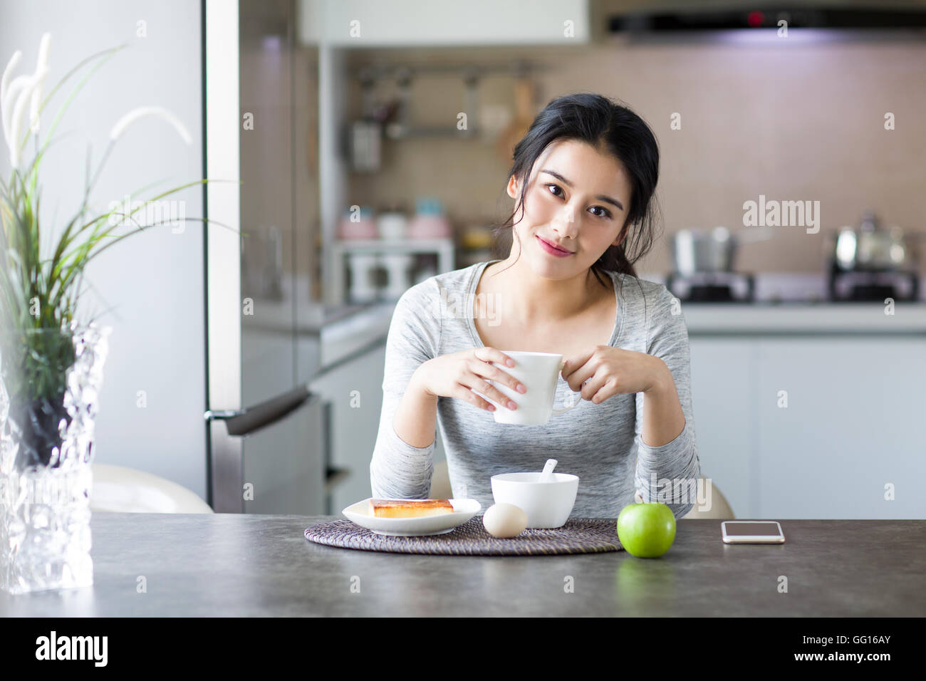 Young Chinese woman eating breakfast at home Stock Photo - Alamy