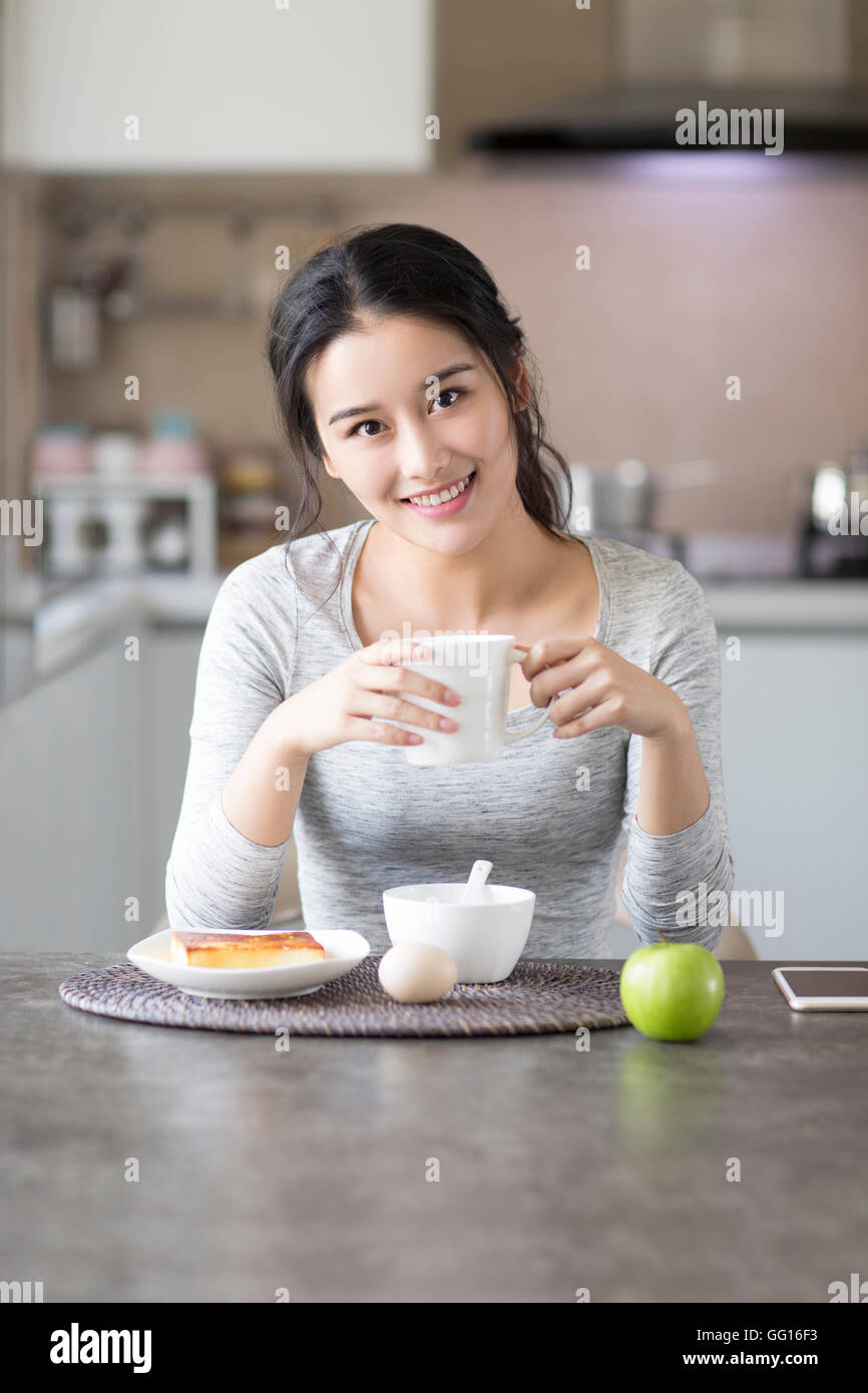 Young Chinese woman eating breakfast at home Stock Photo - Alamy