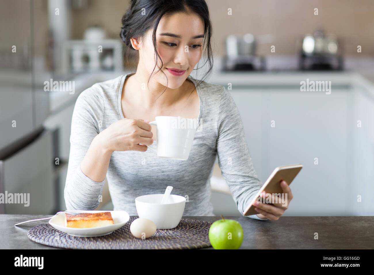 Young Chinese woman eating breakfast at home Stock Photo - Alamy